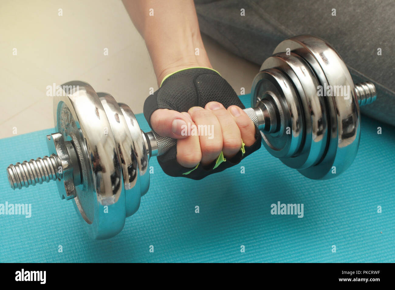 Sitting and using his right hand lifting weights at the shiny steel ...
