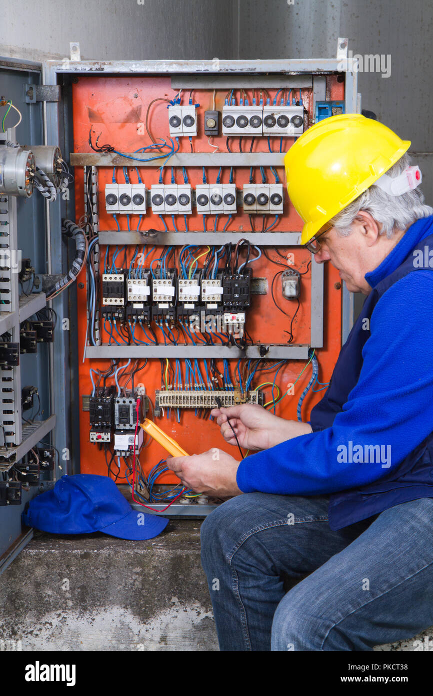 electrician at work with an electric panel Stock Photo - Alamy