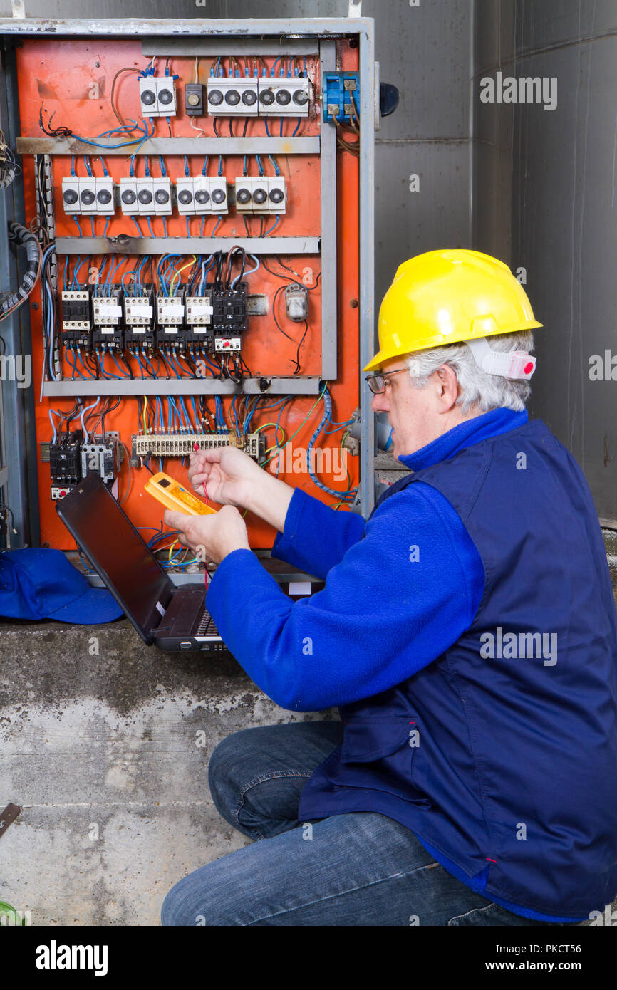 electrician at work with an electric panel Stock Photo - Alamy