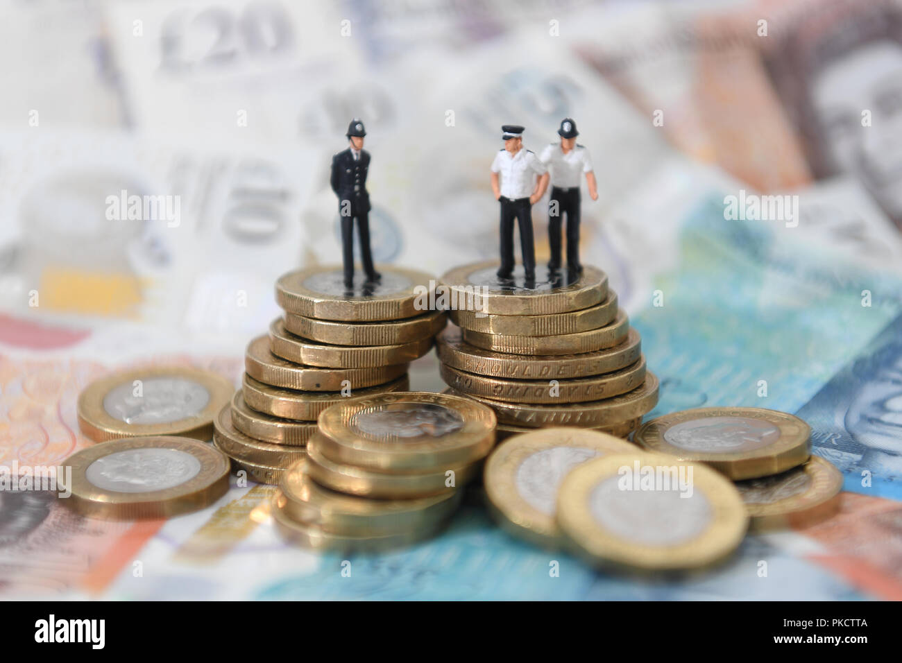 Models of police officers on a pile of coins and bank notes Stock Photo ...
