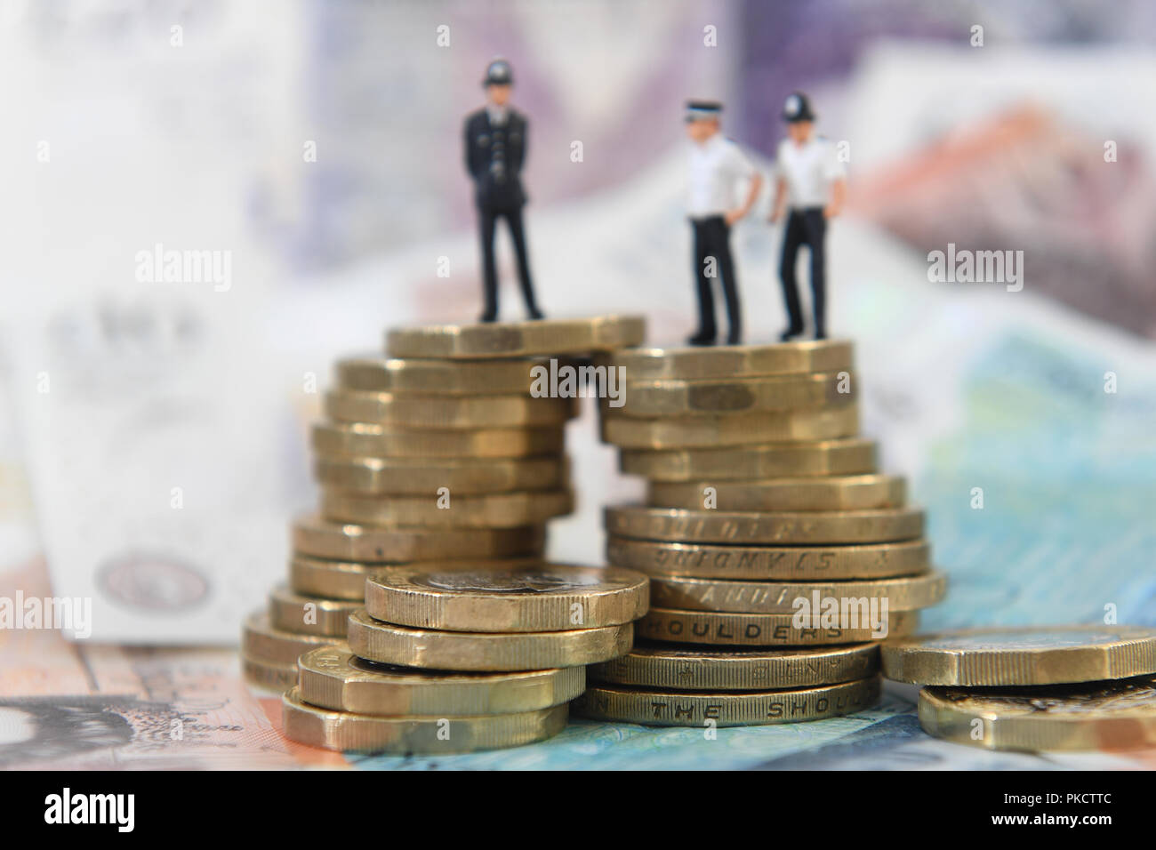 Models of police officers on a pile of coins and bank notes Stock Photo ...