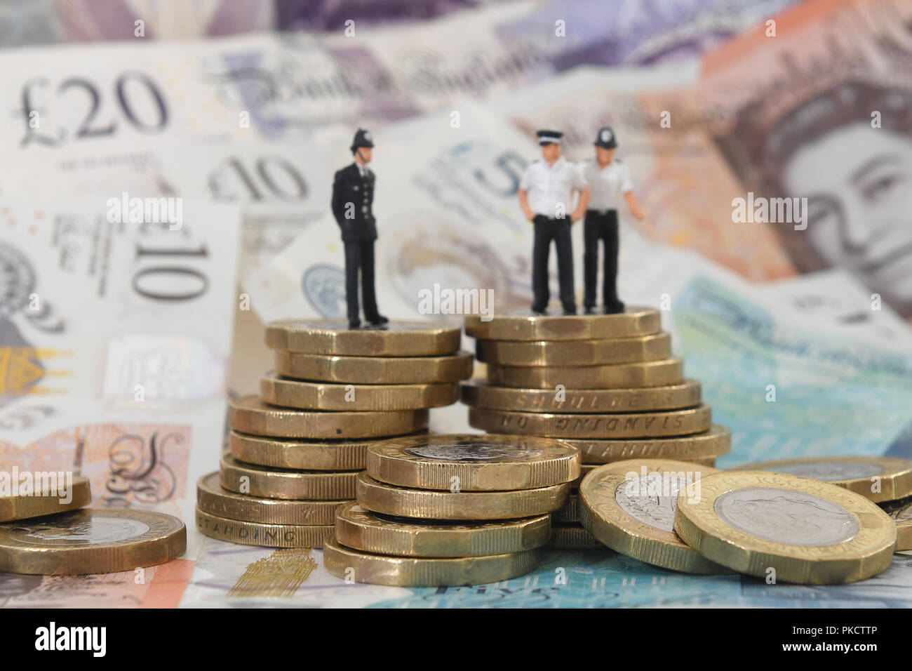 Models of police officers on a pile of coins and bank notes Stock Photo ...