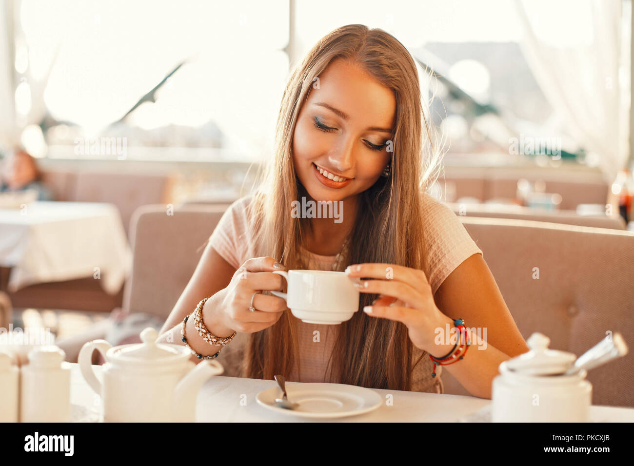 Woman with a smile drinking tea in the restaurant Stock Photo - Alamy