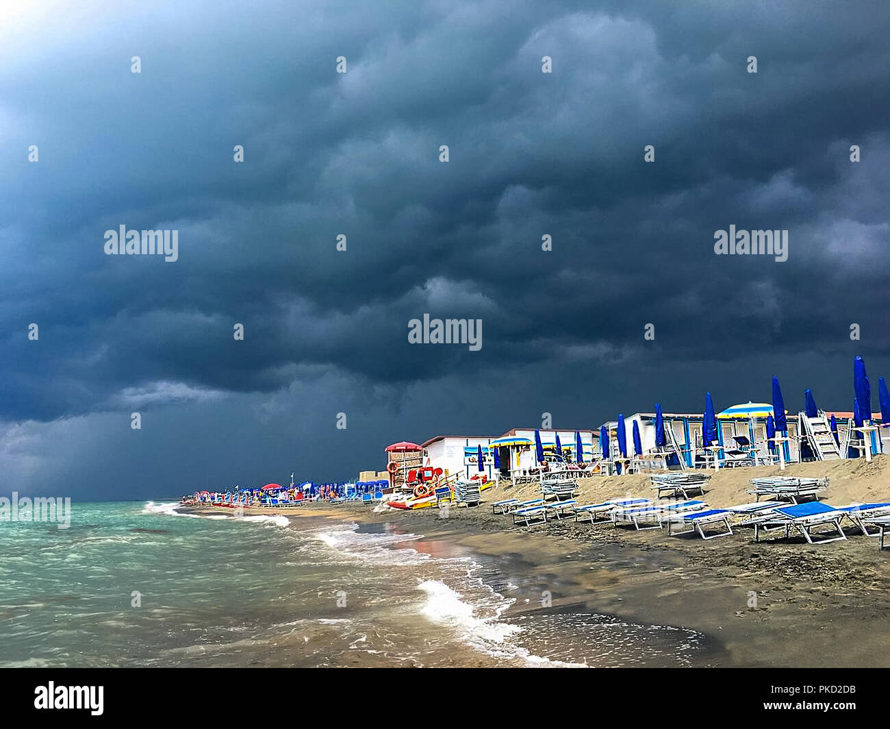 summer storm on a beach with deckchair and beach umbrellas Stock Photo - Alamy