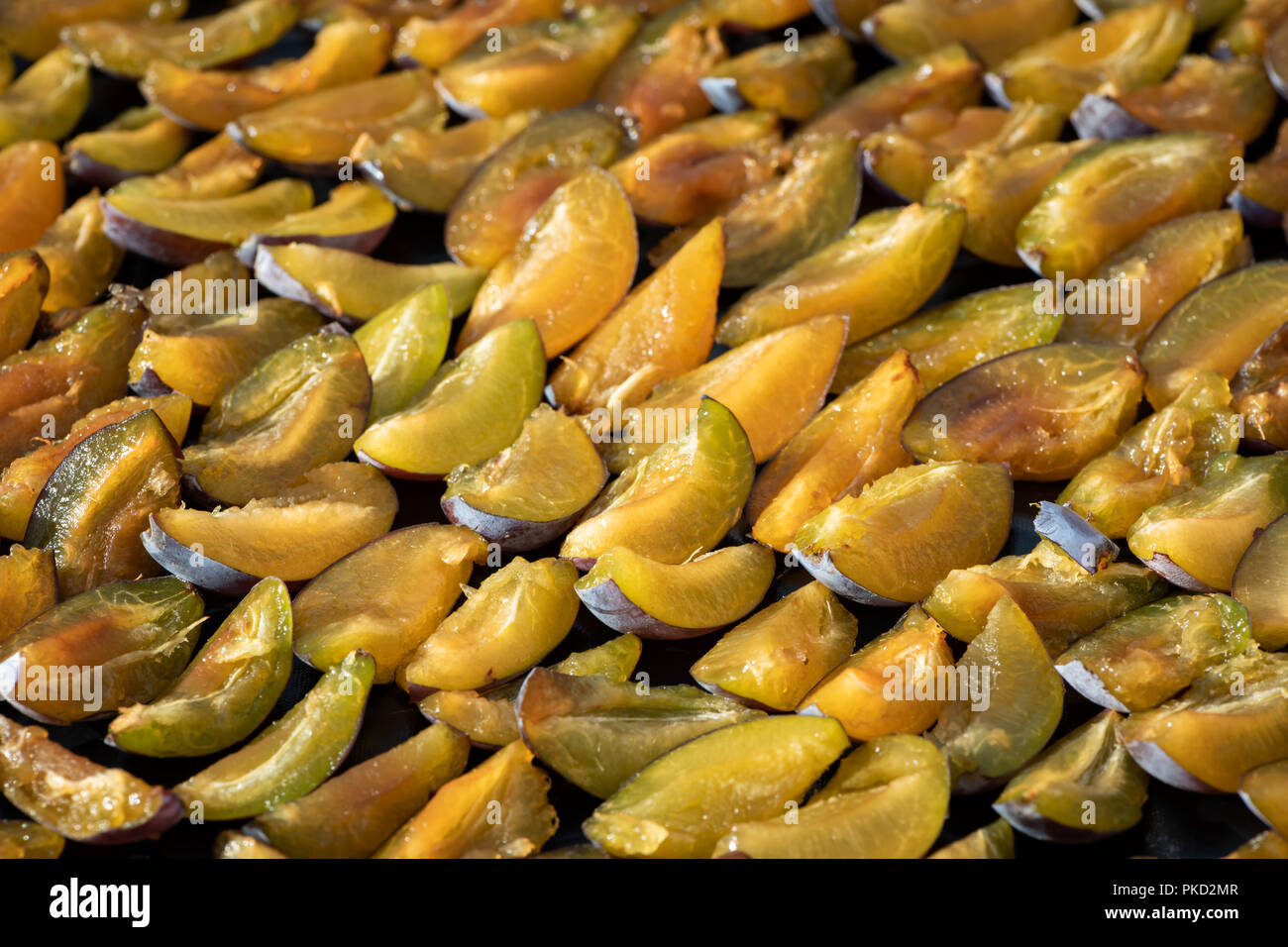 Plums cut in half laid in rows on a tray to dry Stock Photo - Alamy