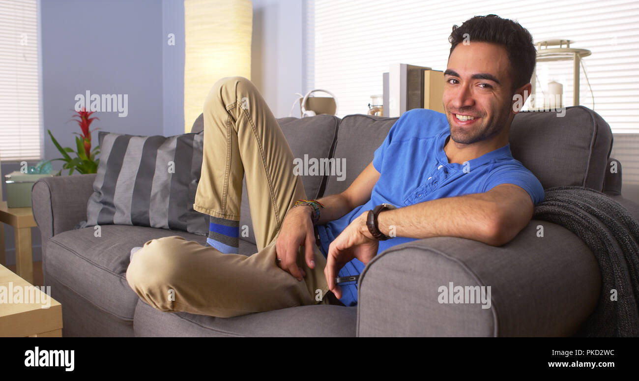 Happy Mexican man resting on couch Stock Photo - Alamy