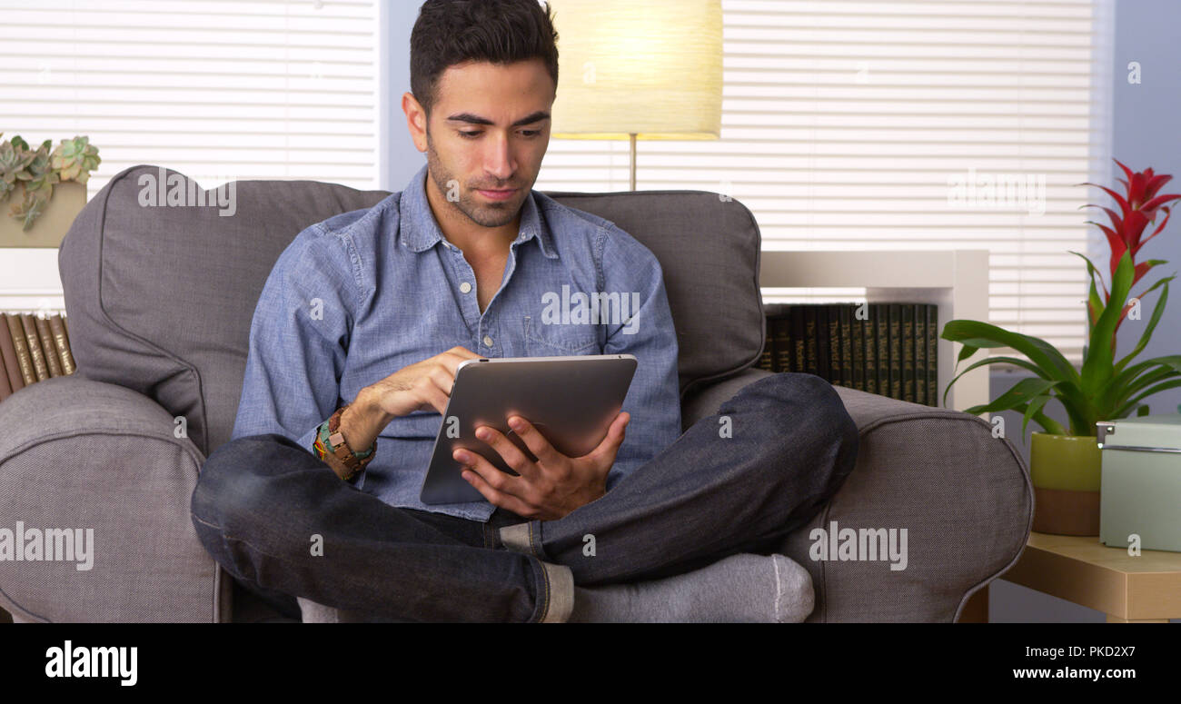 Mexican guy reading on his tablet Stock Photo - Alamy