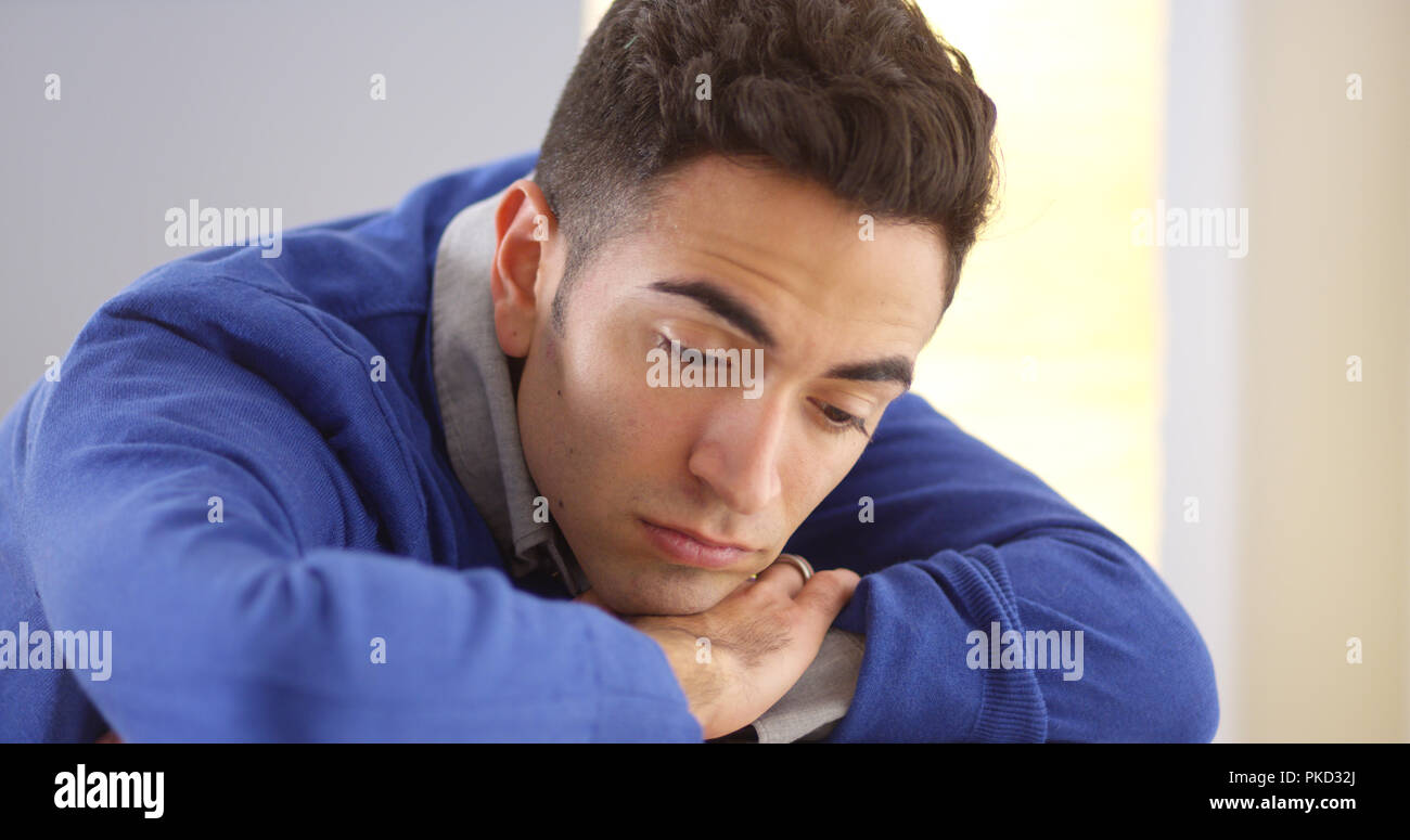 Moody Mexican man resting on desk Stock Photo - Alamy