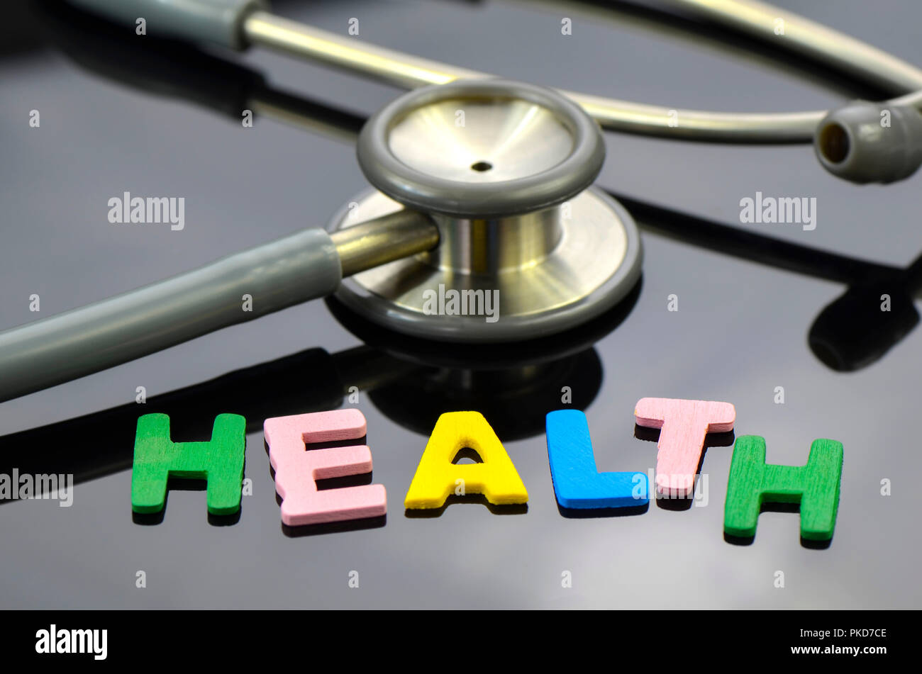 HEALTH letter with stethoscope on dark background Stock Photo - Alamy