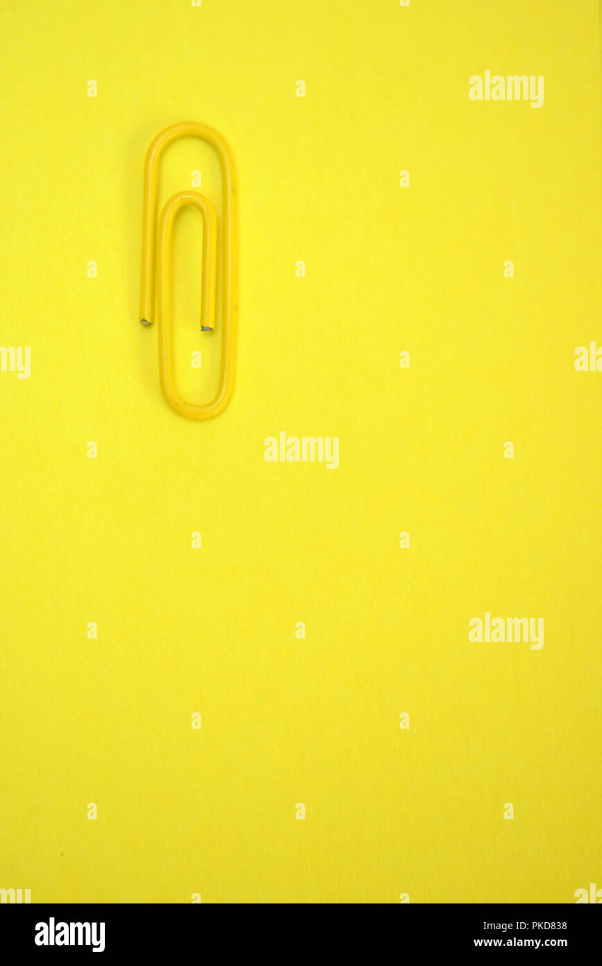 Isolated yellow paper clips on yellow paper Stock Photo - Alamy