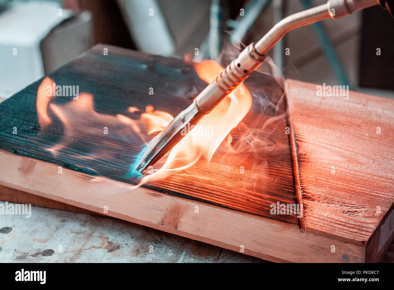Burning wood planks in carpentry joint in Italy. Detail of gas burner ...