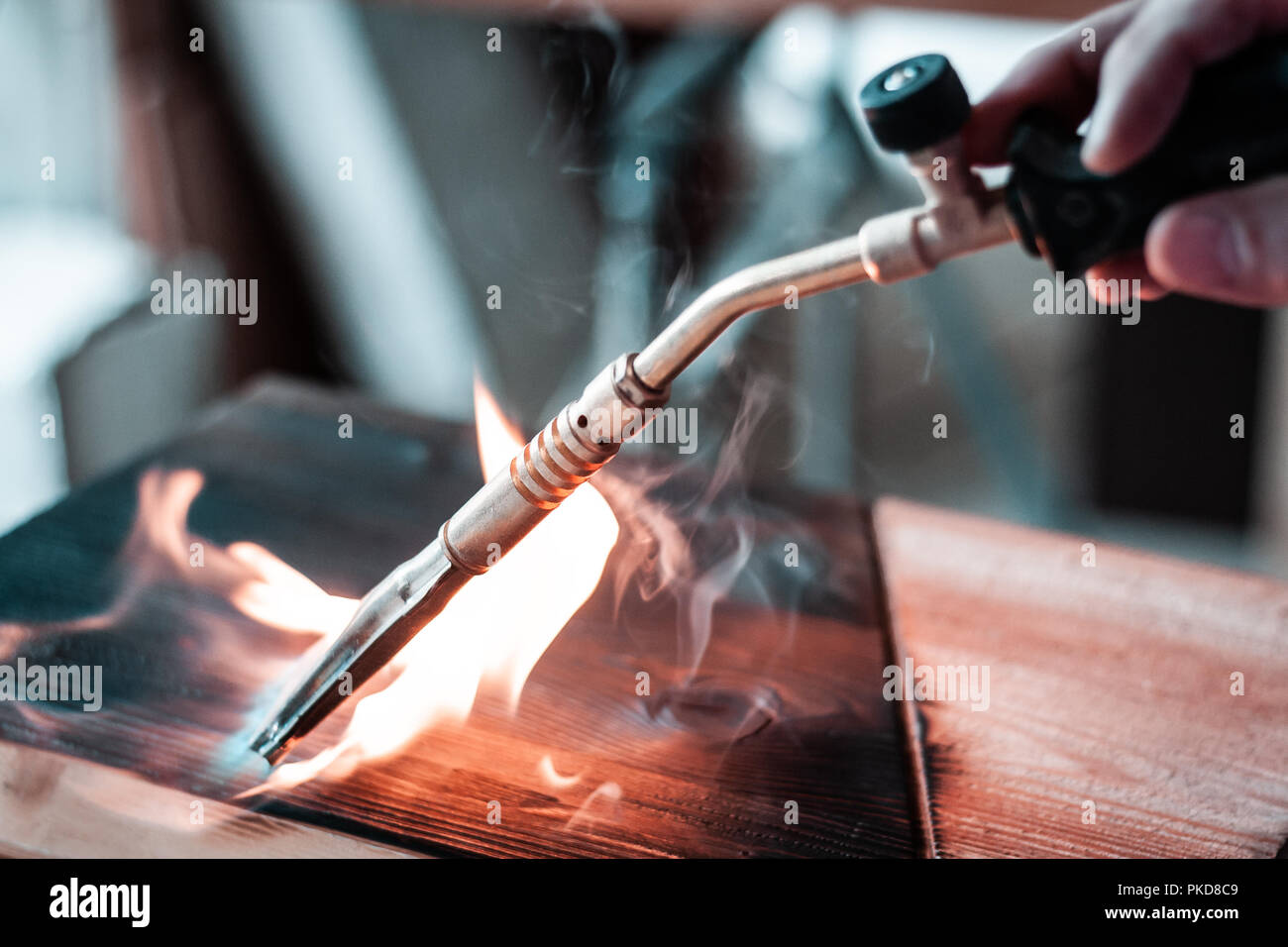 Burning wood planks in carpentry joint in Italy. Detail of gas burner ...