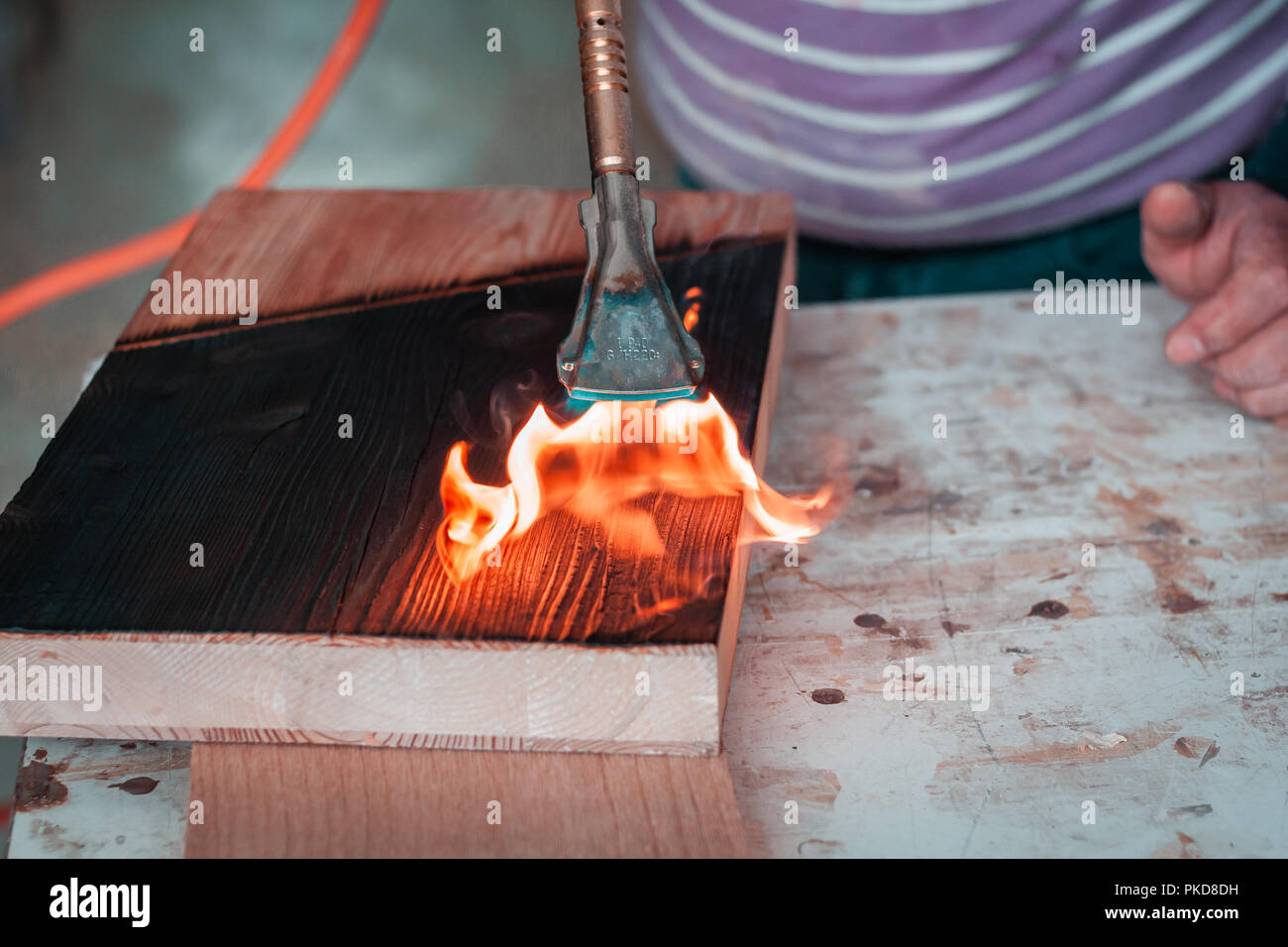 Burning wood planks in carpentry joint in Italy. Detail of gas burner ...