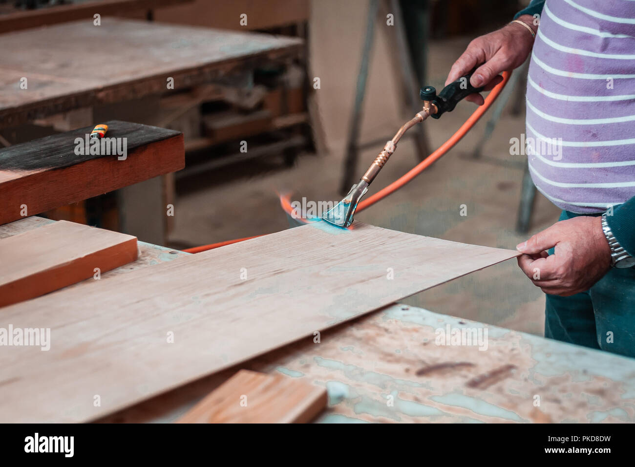 Burning wood planks in carpentry joint in Italy. Detail of gas burner ...