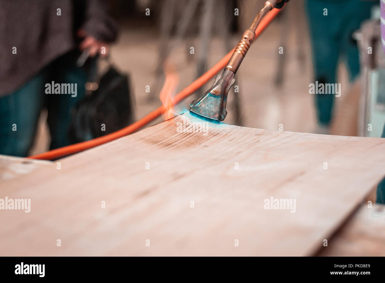 Burning wood planks in carpentry joint in Italy. Detail of gas burner ...