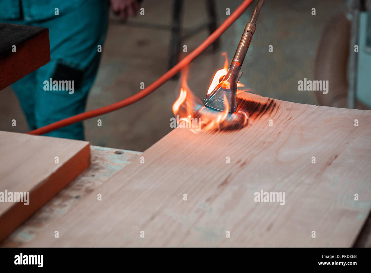 Burning wood planks in carpentry joint in Italy. Detail of gas burner ...