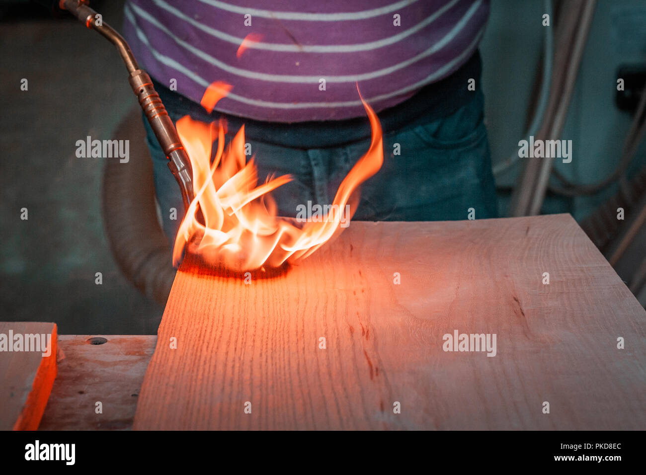 Burning wood planks in carpentry joint in Italy. Detail of gas burner ...