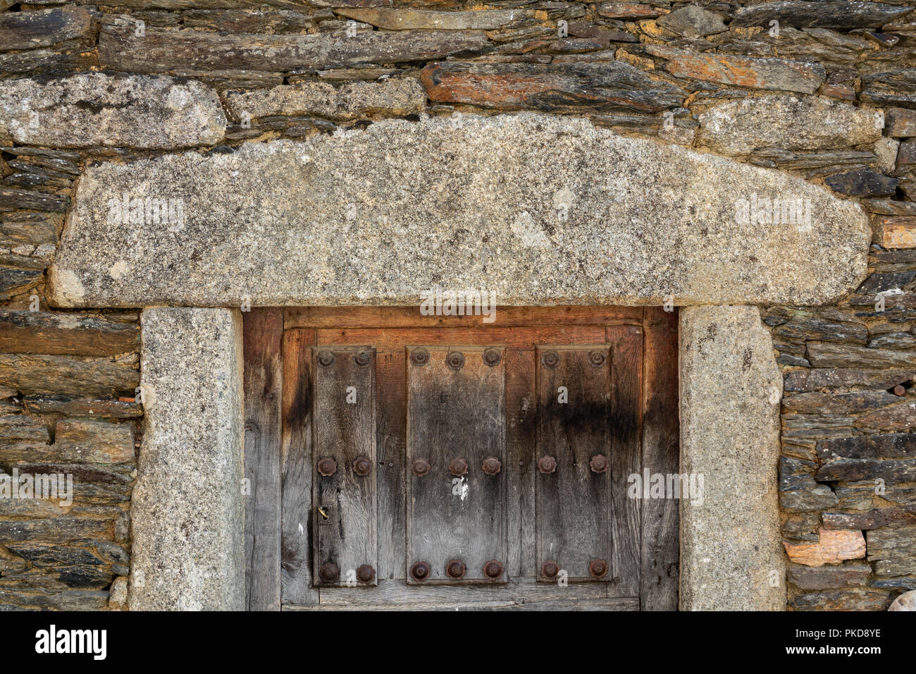 Granite frame, stone facade and vintage wooden door Stock Photo - Alamy