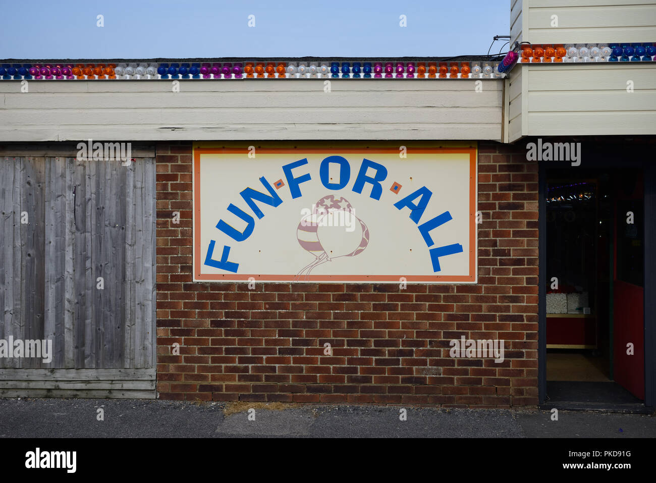 A sign saying Fun For All outside an amusement arcade in England Stock ...