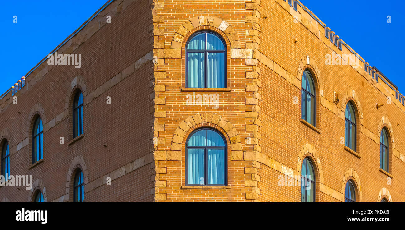 Blue sky behind corner building with mid day sun Stock Photo - Alamy