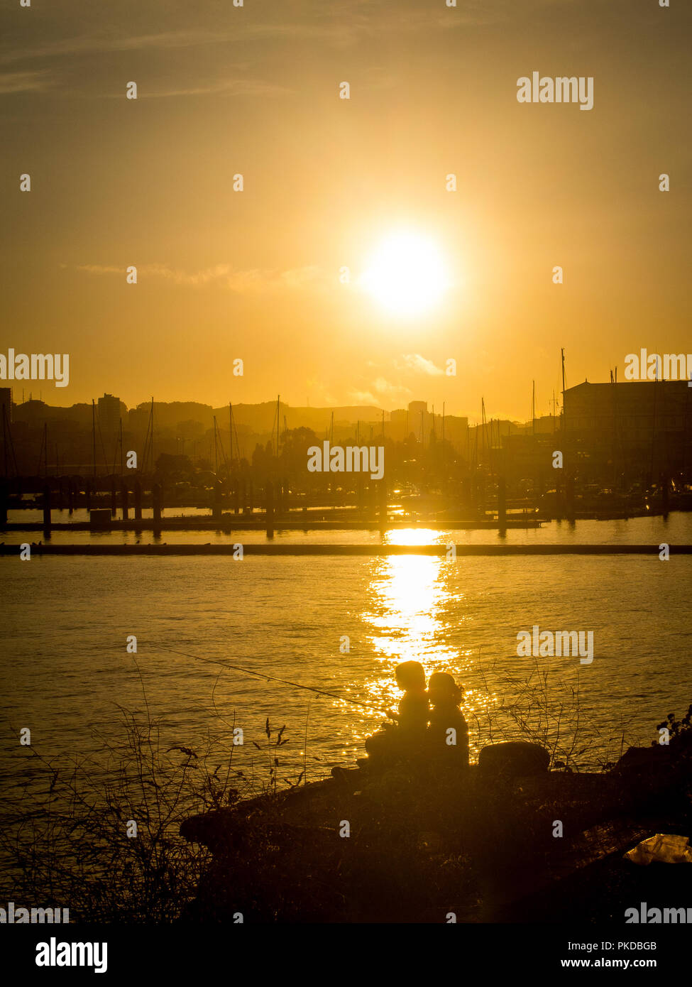 Mother and kid fishing in back-lighting Stock Photo - Alamy