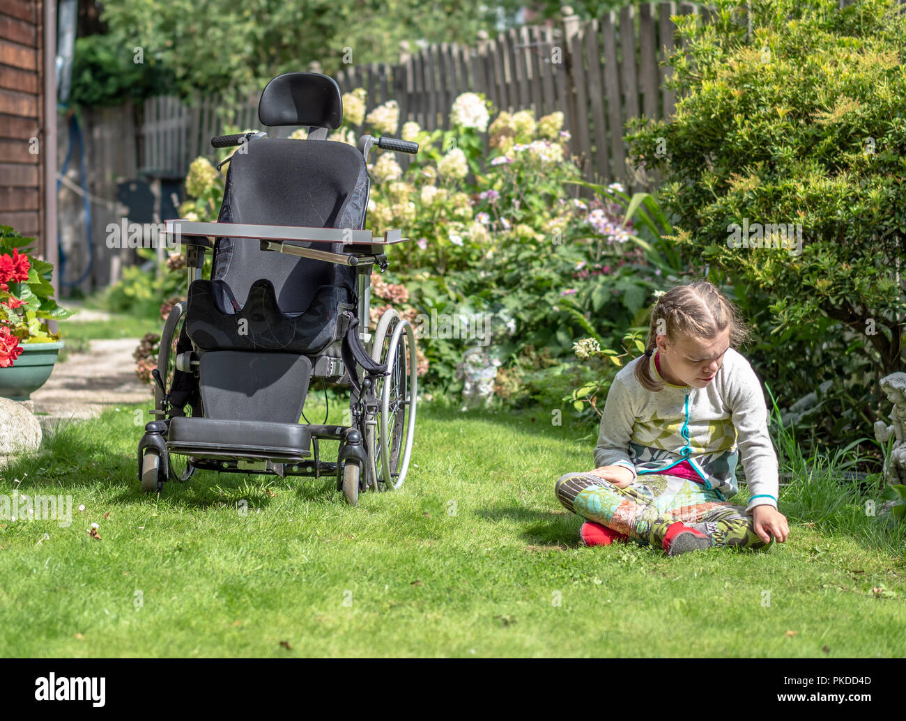 A disabled child having a break from sitting in her wheelchair to ...