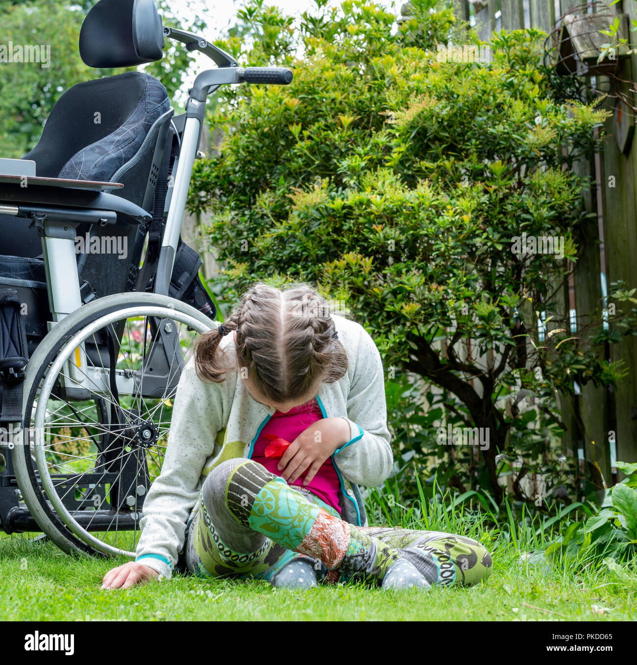 A disabled child having a break from sitting in her wheelchair to ...