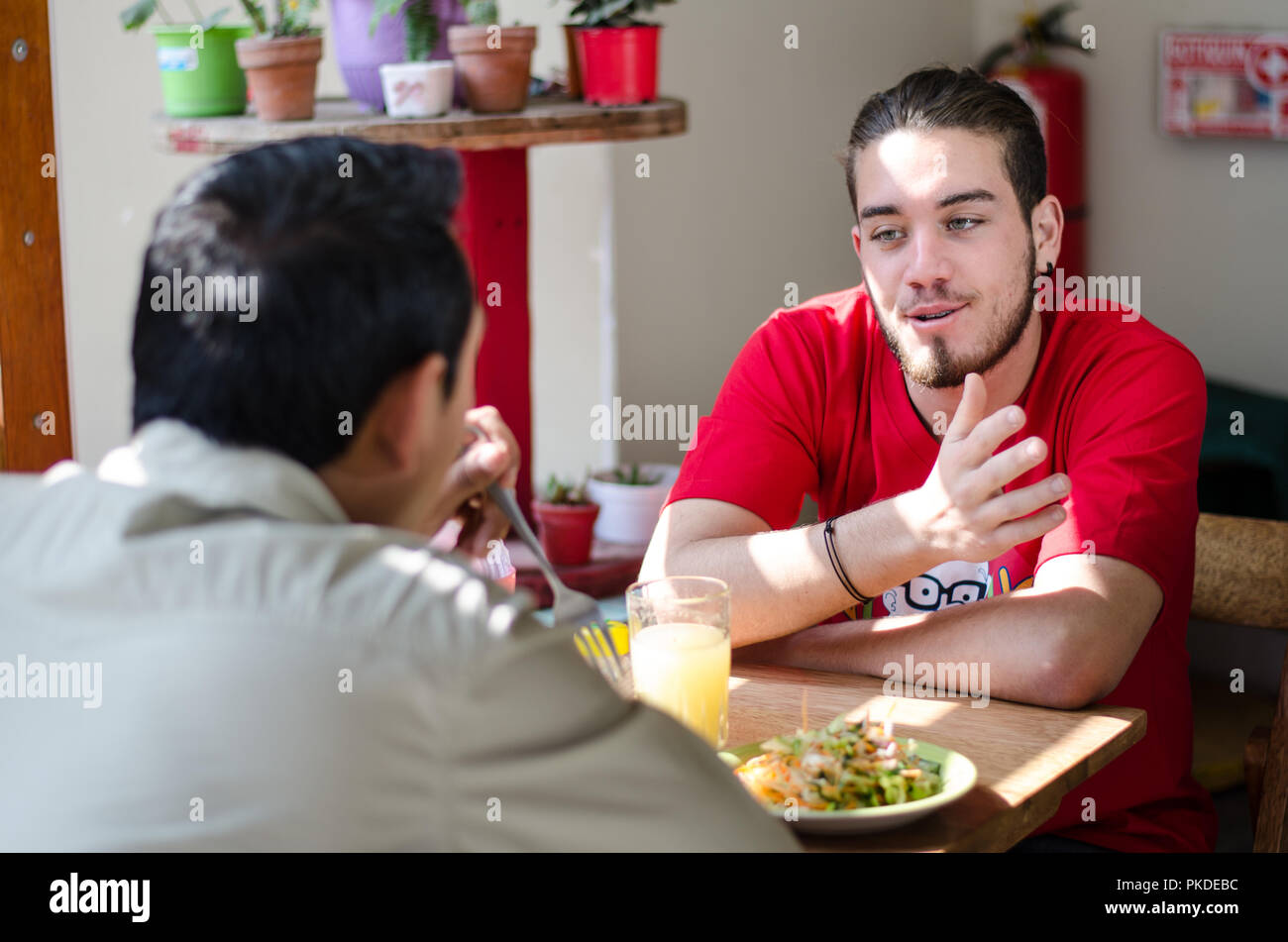 Good looking men having lunch in an outdoor restaurant, men chatting ...