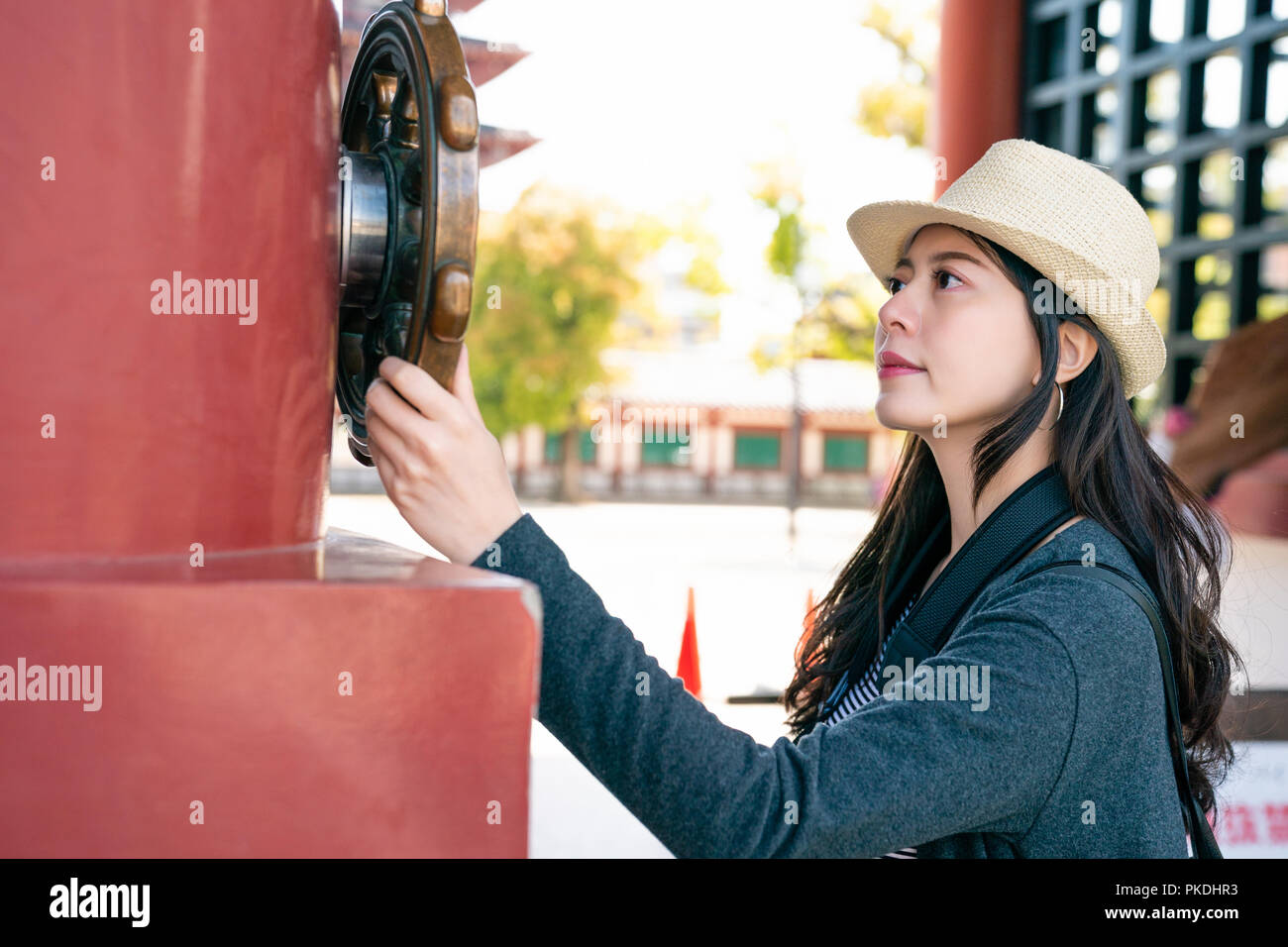 attractive asian woman admiring and touching the wooden sculpture ...
