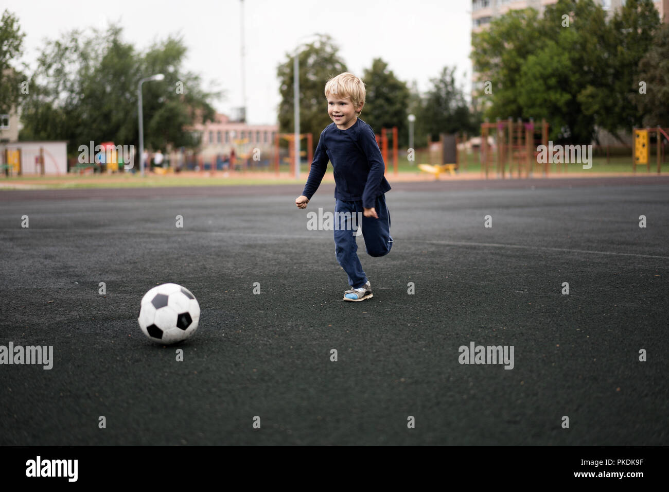 active lifestyle in a modern city - little boy playing with a soccer ...