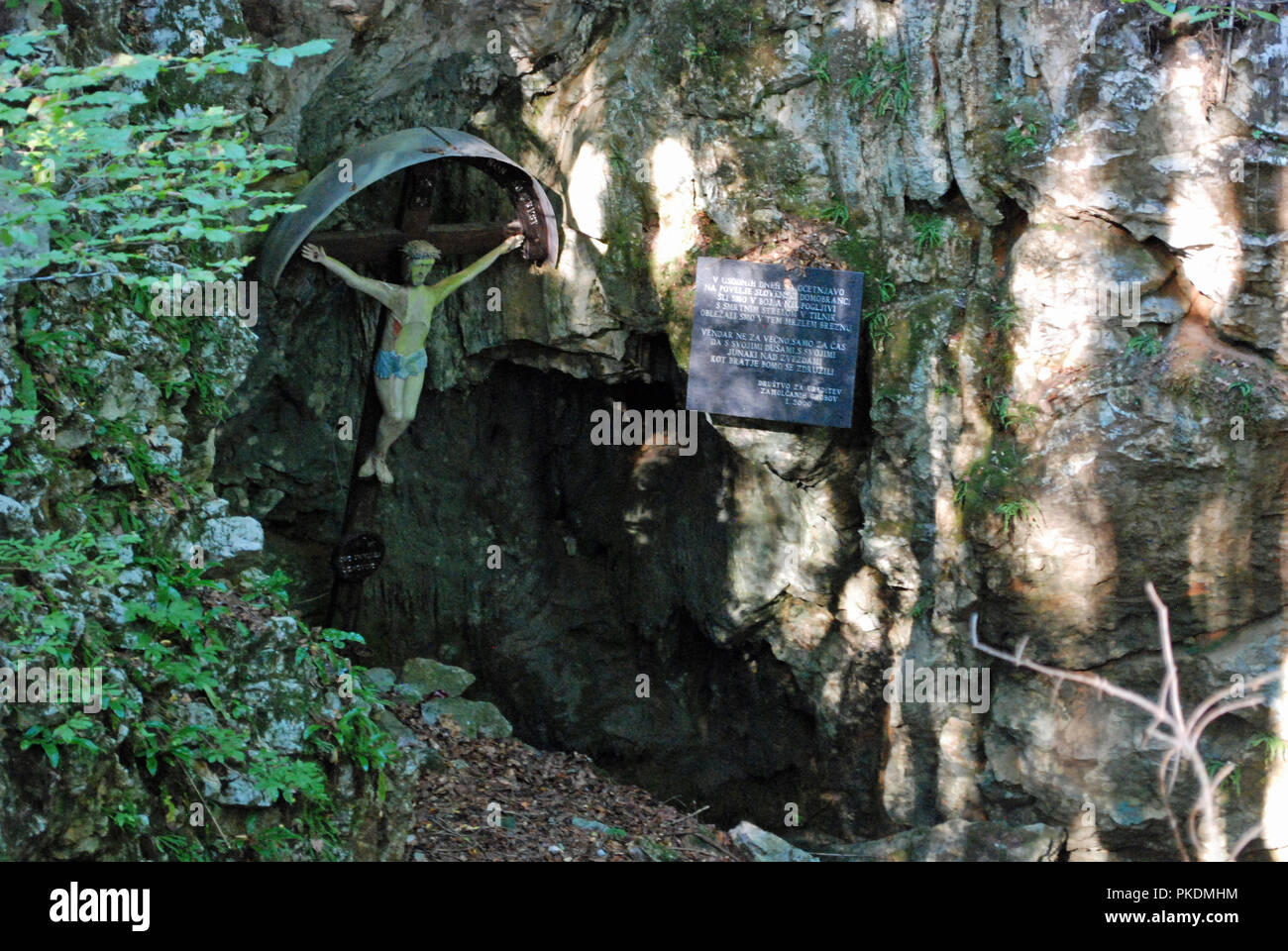 A crucified Jesus hangs over the cave entrance to Jama Pod Macesnovo ...