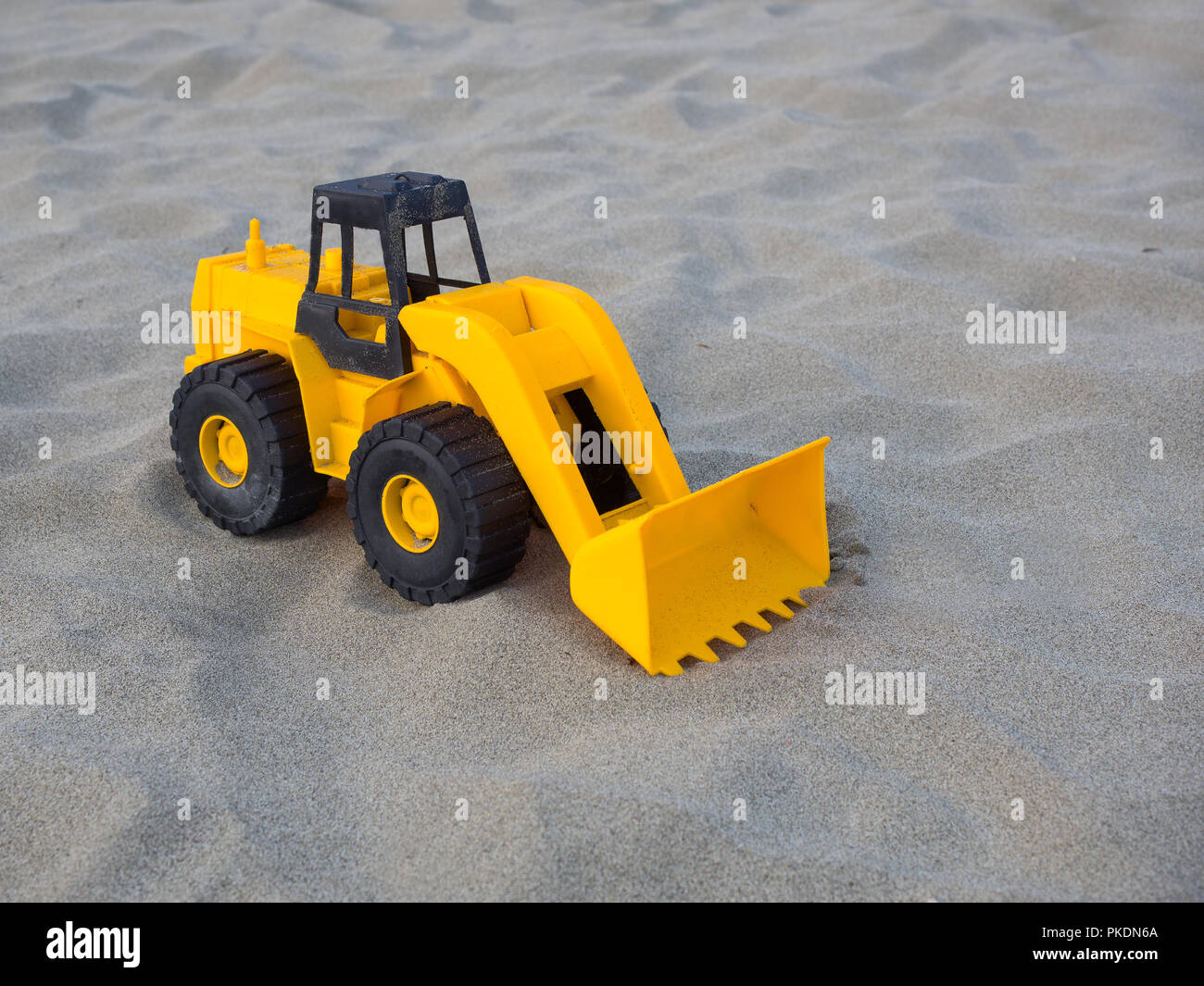 toy wheel loader excavator, contruction machine, on the sand at the ...