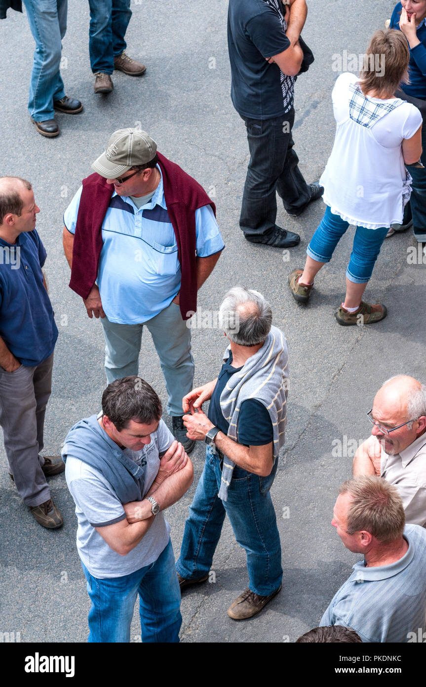 Overhead view of large group of people talking at roadside - France ...