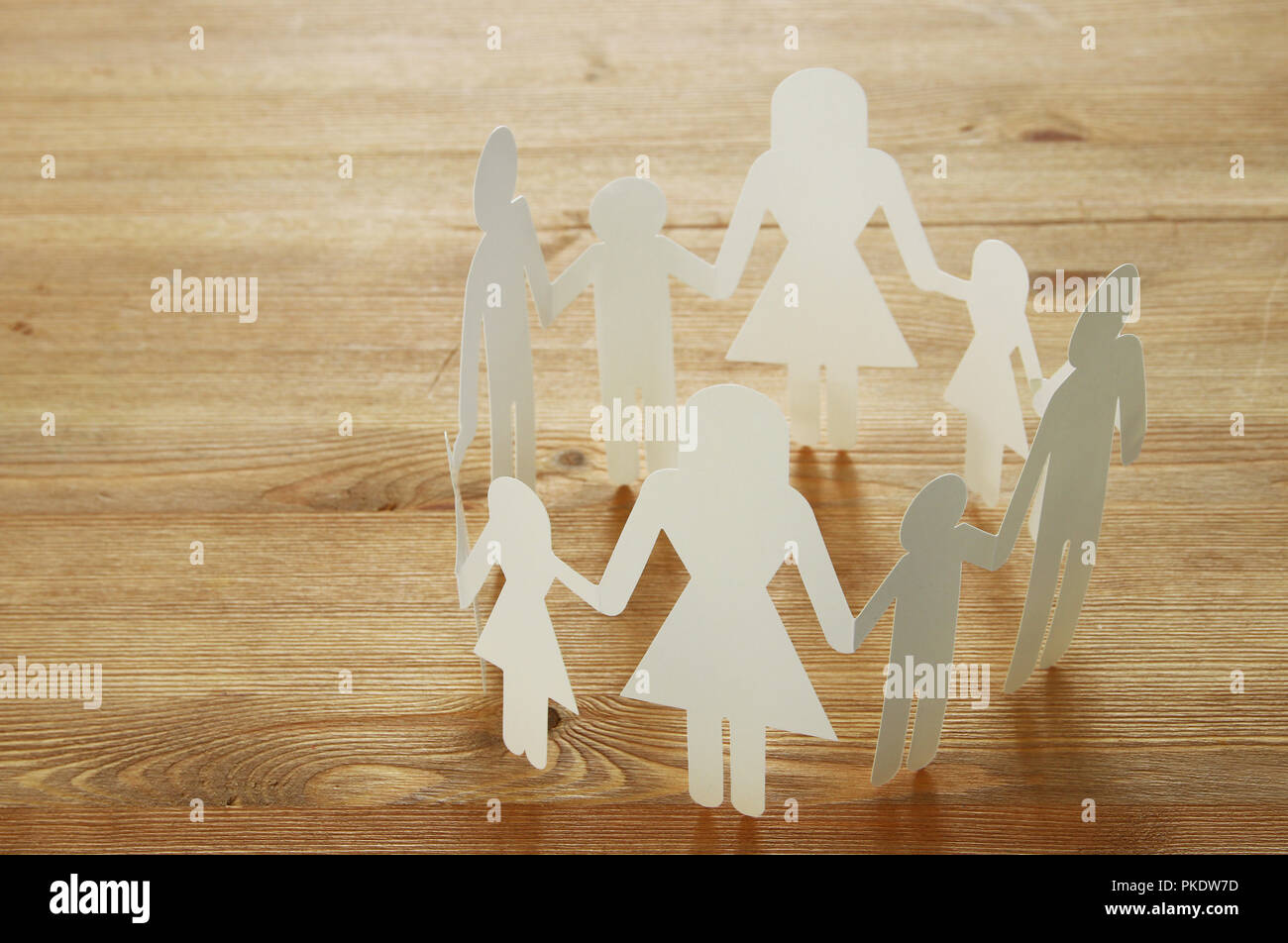 concept image of Family paper chain cutout holding hands, over wooden ...