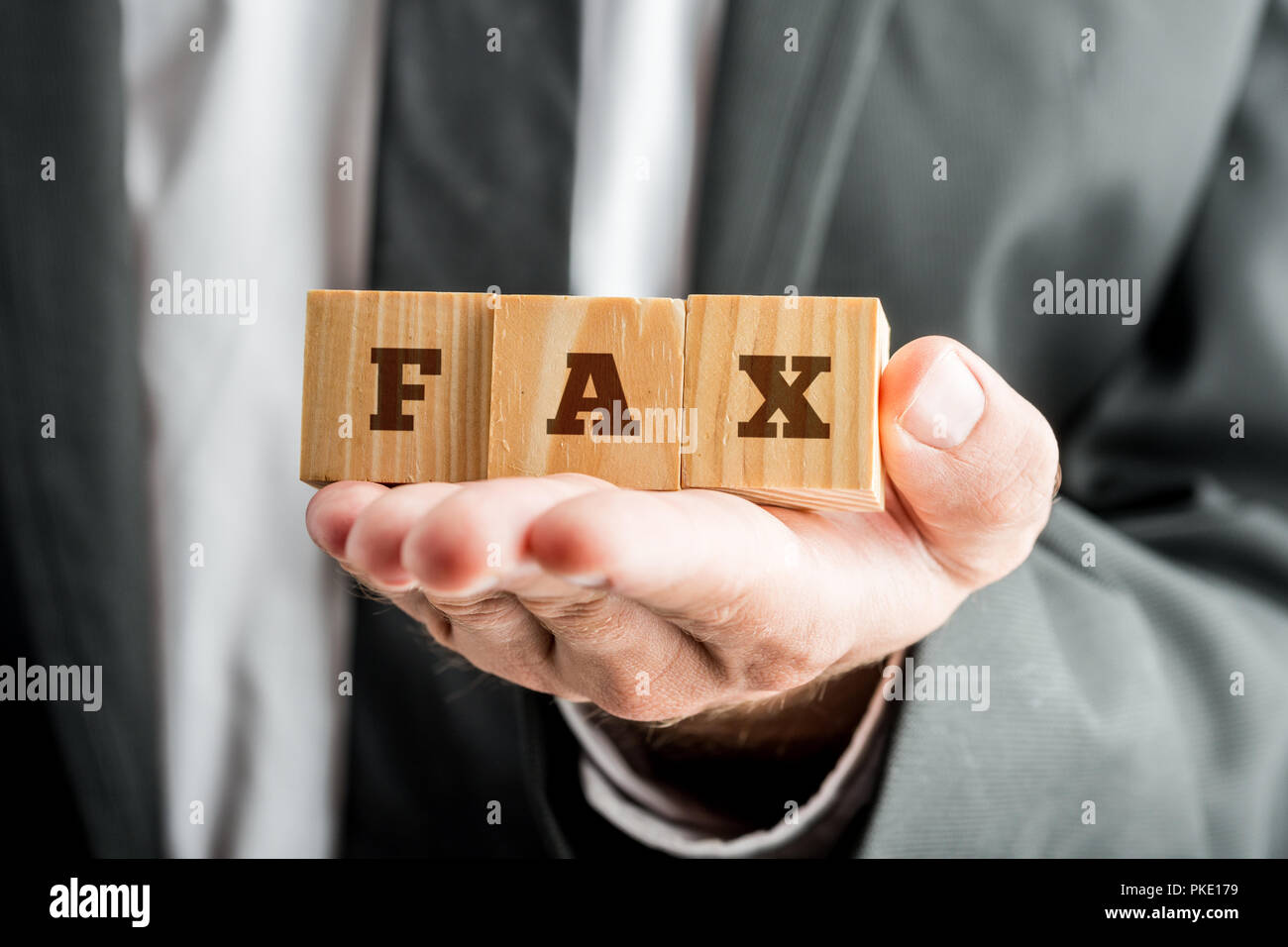 Front closeup view of businessman hand holding three wooden cubes ...