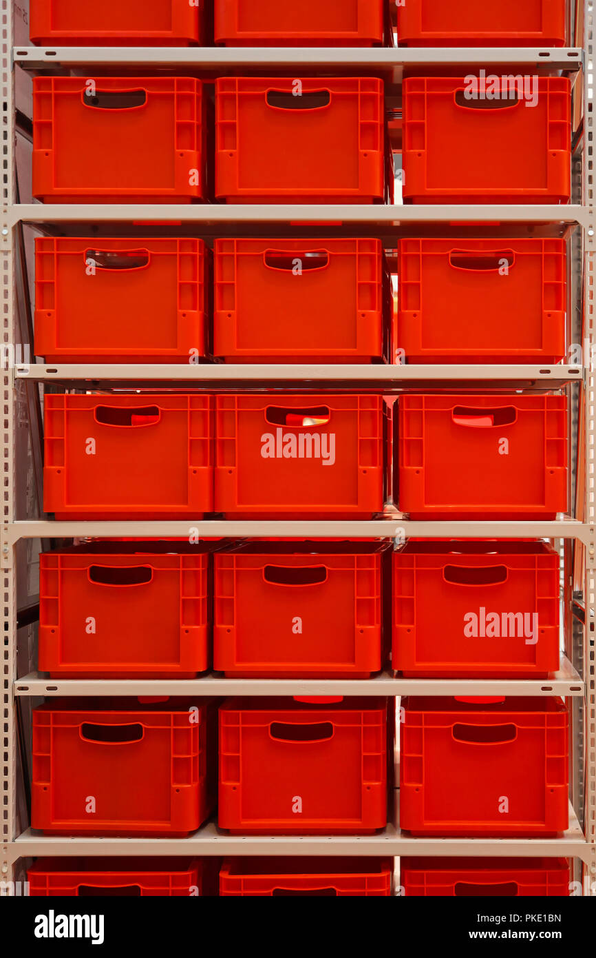 Shelf with red plastic crates in warehouse Stock Photo - Alamy