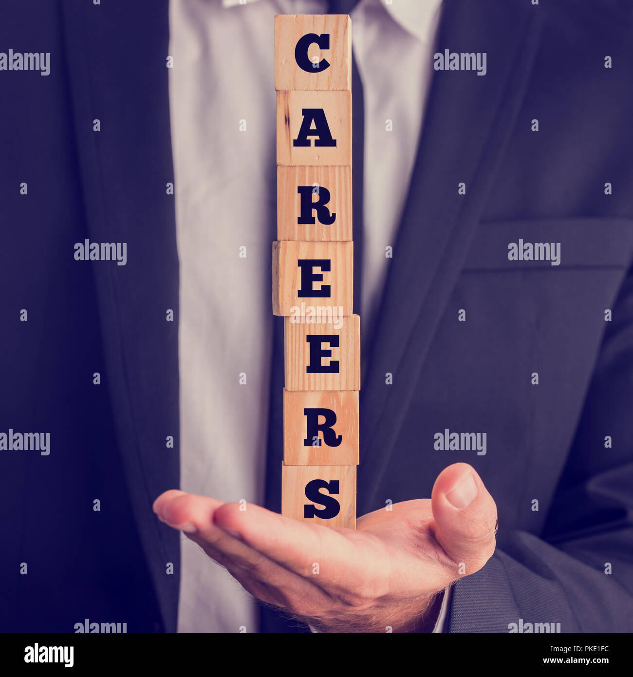 Close Up of Businessman Holding Vertical Stack of Letter Blocks ...