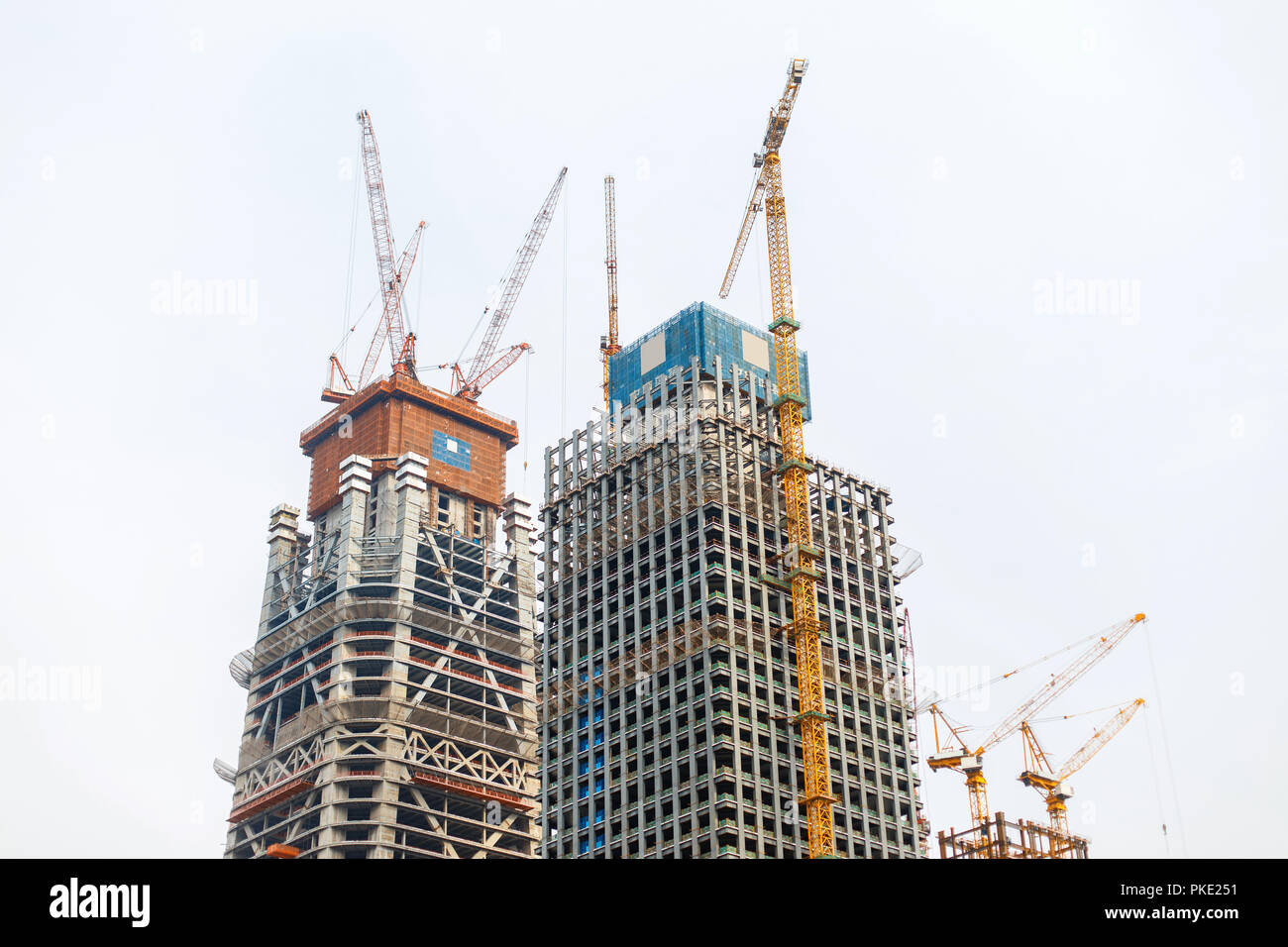 Construction. Cranes building modern skyscraper Stock Photo - Alamy