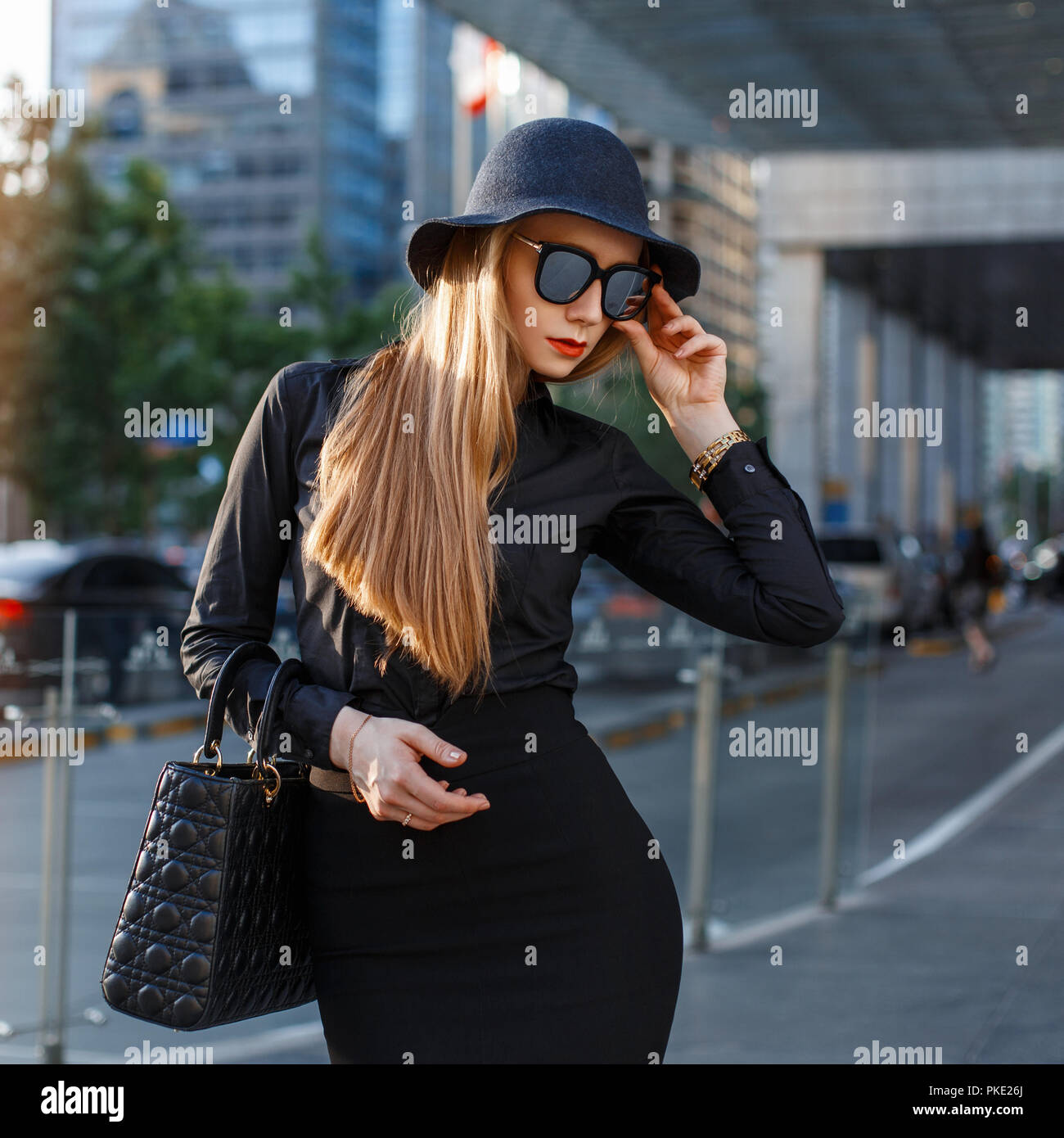 Successful stylish young girl in fashionable clothes on a background of ...