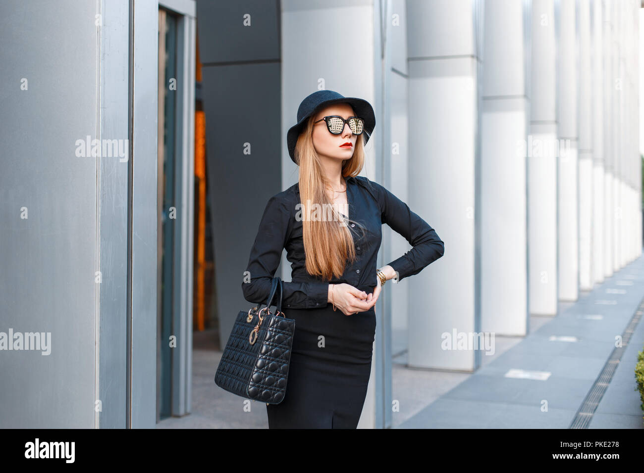 Successful stylish young girl in a strict fashion clothes with a hat ...