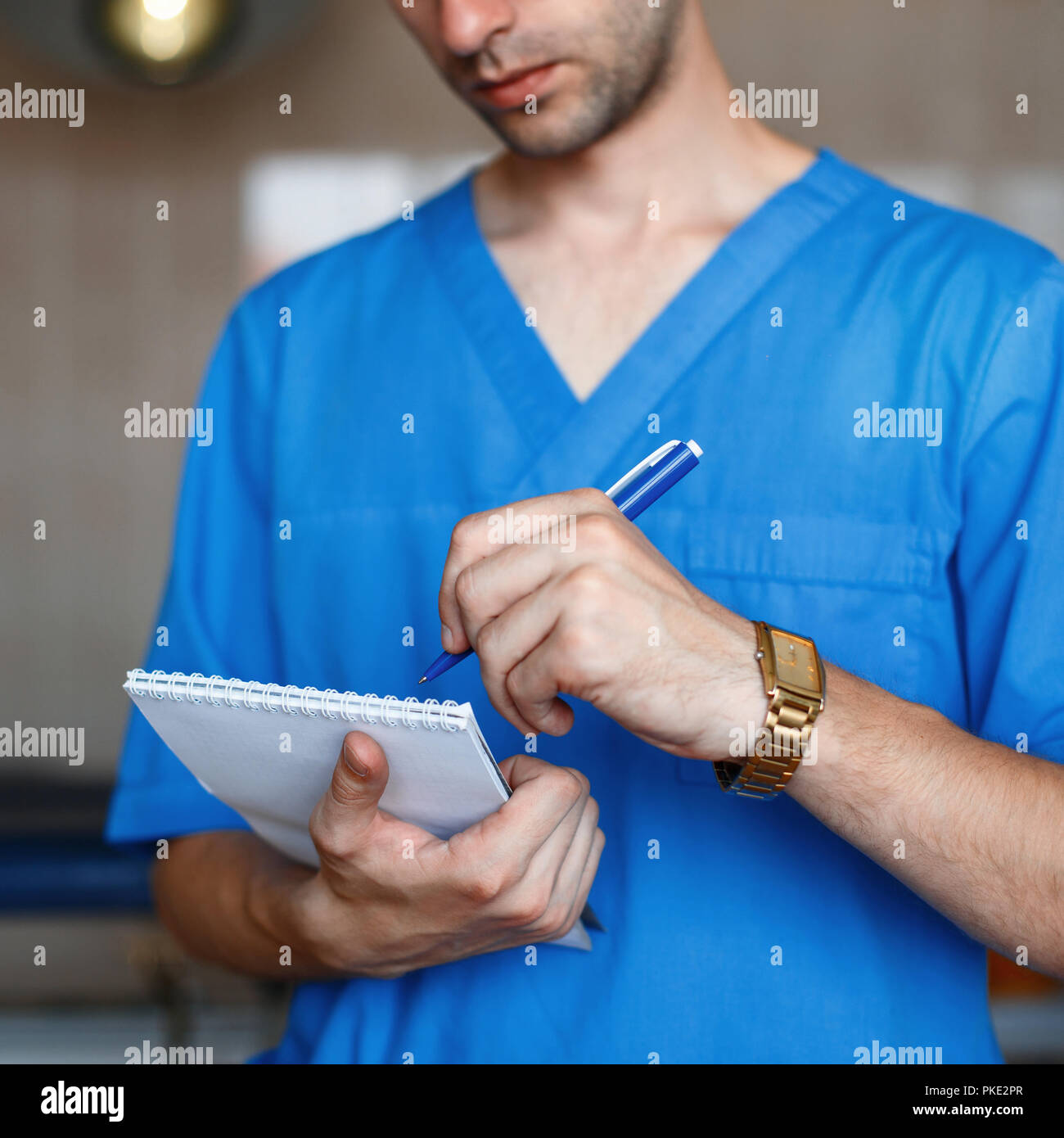 Doctor holding a pen and writes in a notebook Stock Photo - Alamy