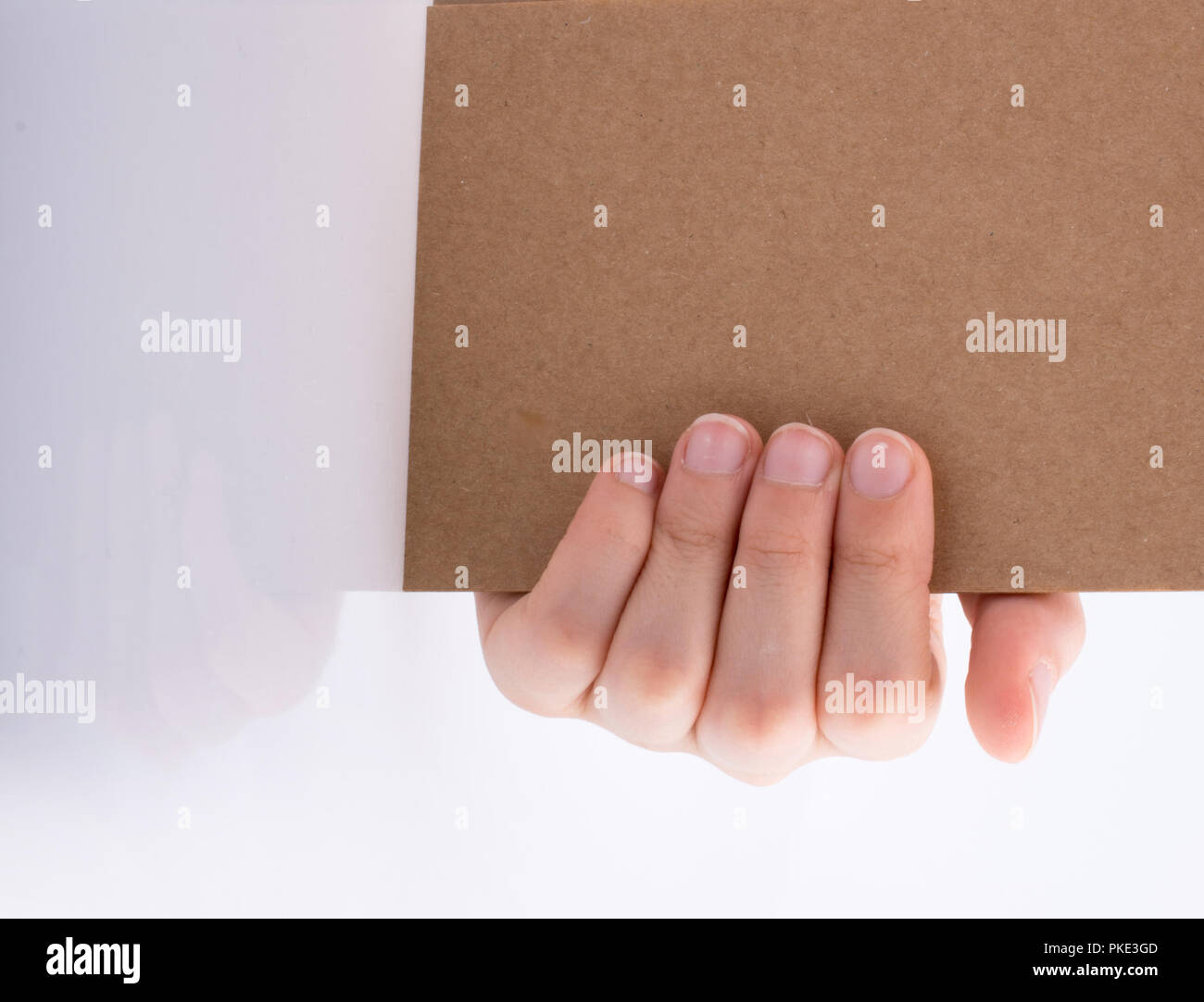 Hand holding brown color notebook on a white background Stock Photo - Alamy