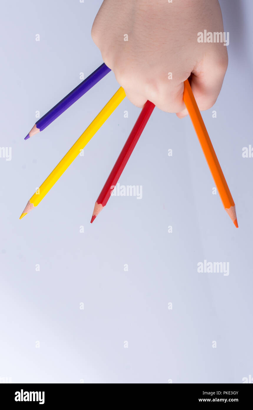 Hand holding color Pencils placed on a white background Stock Photo - Alamy