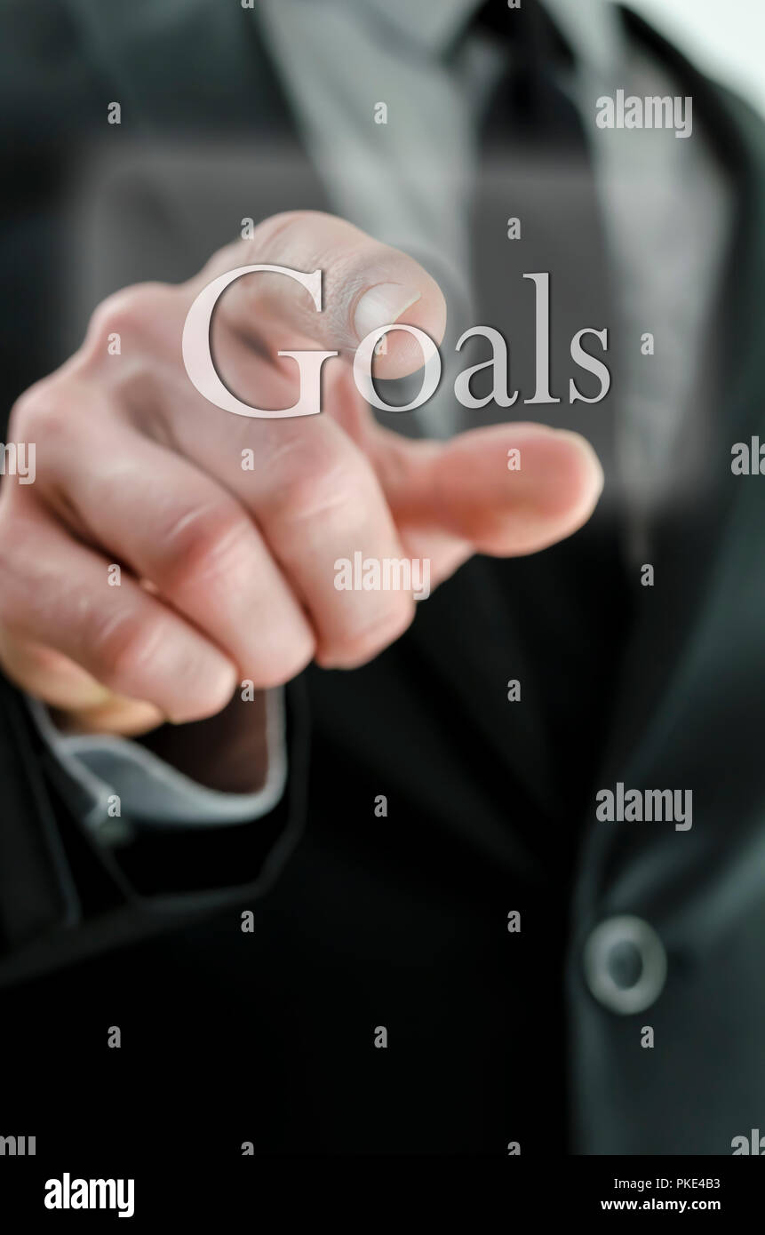 Detail of businessman hand pointing at Goals icon on a touch screen ...