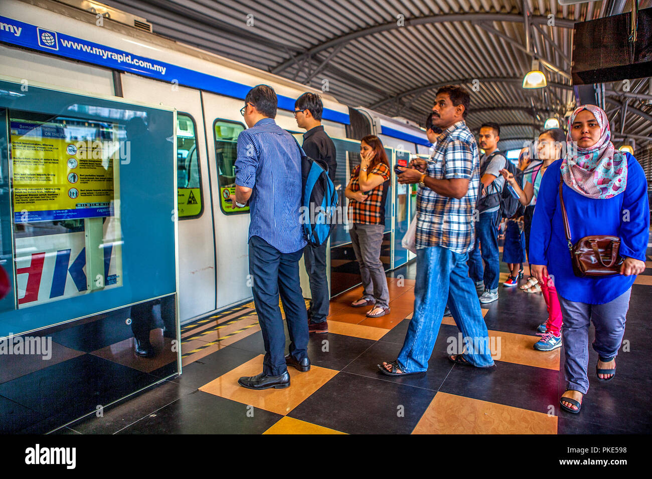 Passengers wait to board a passenger car of a KL rapid transit commuter ... Passengers wait to board a passenger car of a KL rapid transit commuter ...