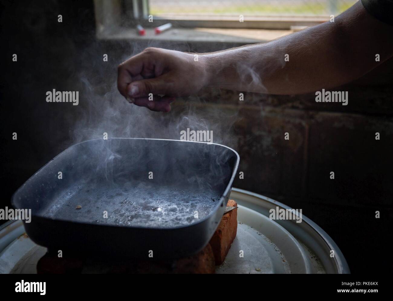 A U.S. Marine heats a CS capsule during gas chamber training at Marine ...