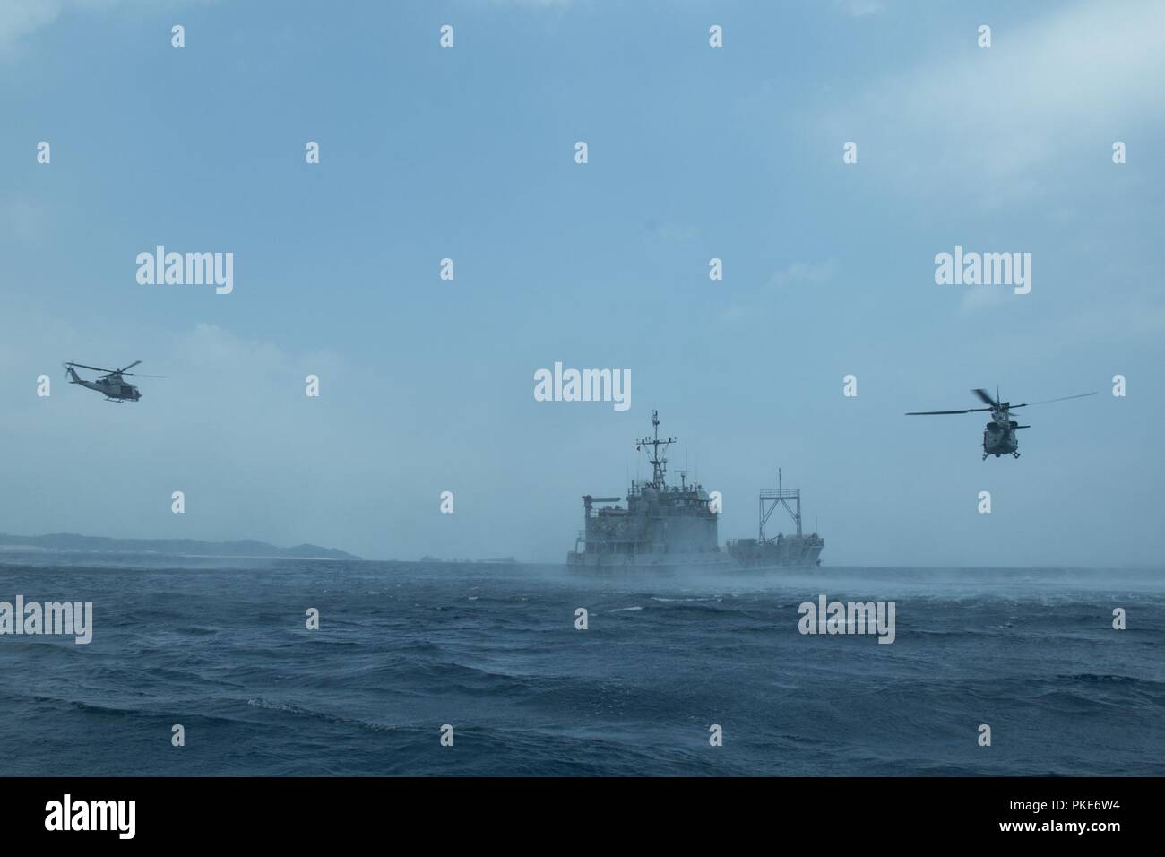 UH-1Y Huey helicopters flank a U.S. Army landing craft during a Visit ...