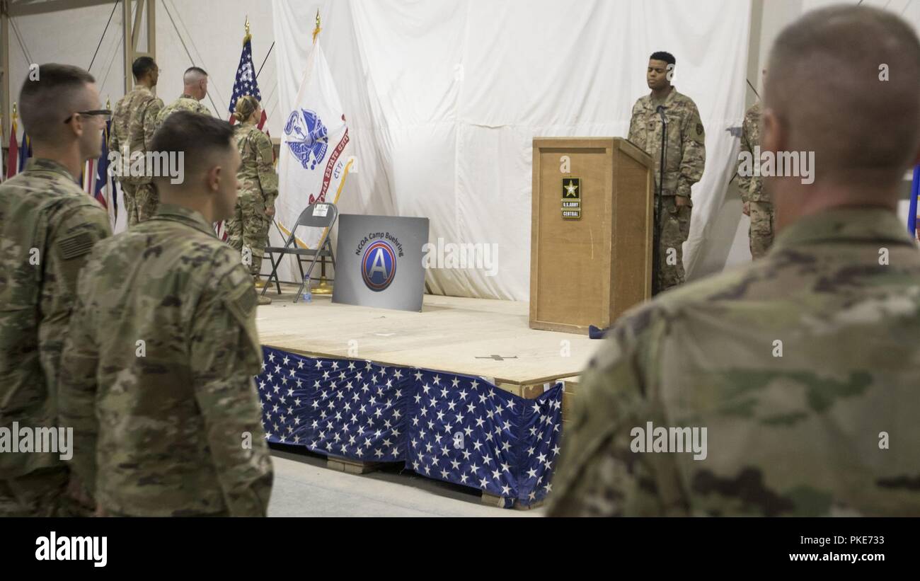 Graduating Soldiers and guests stand at attention for the National ...