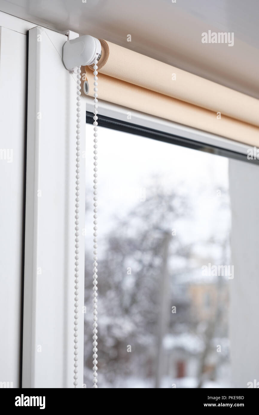 Beige blackout roller blind on the white plastic window. Shutters on ...
