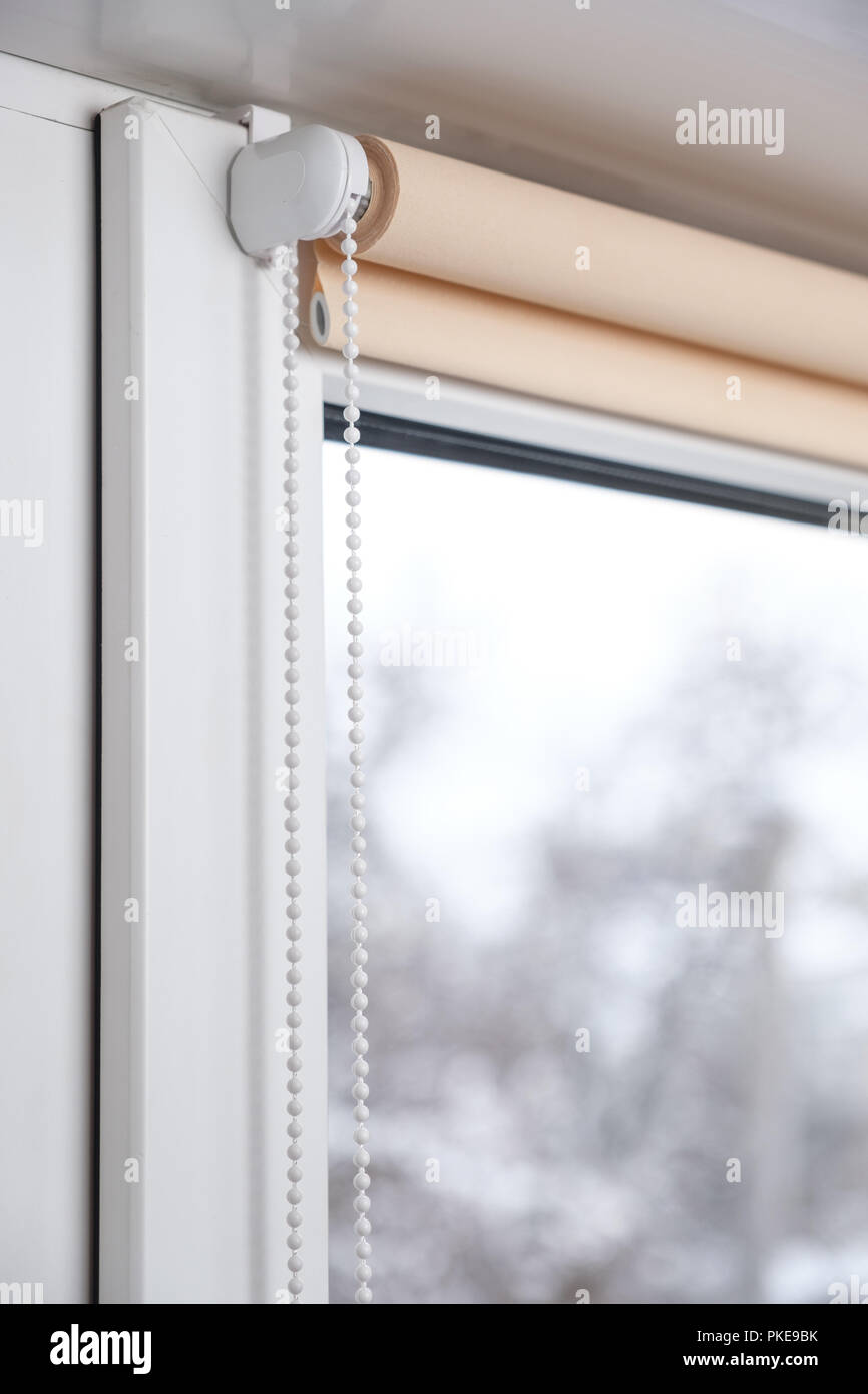 Beige blackout roller blind on the white plastic window. Shutters on ...